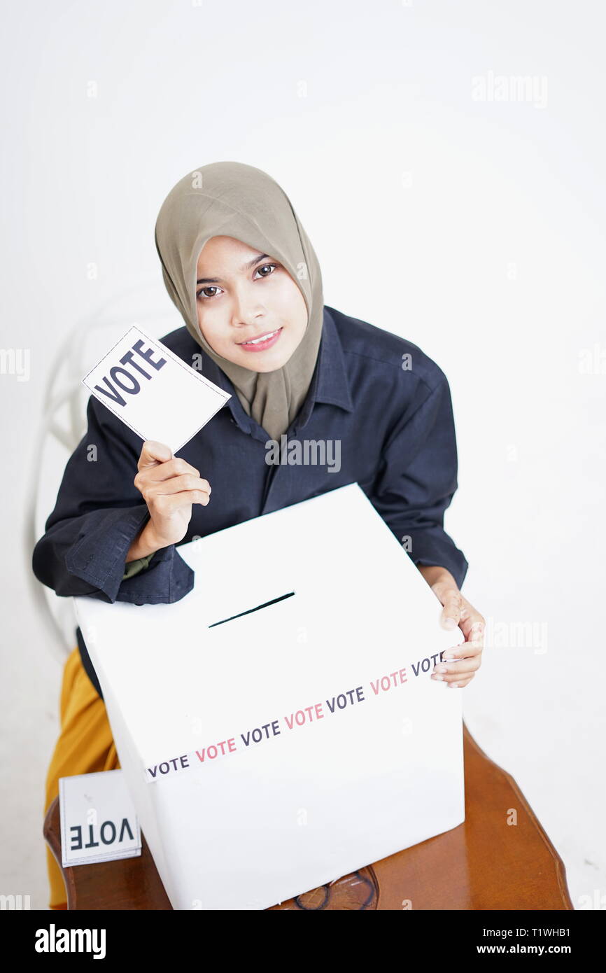 Hijab girl putting a ballot into a Ballot box Stock Photo - Alamy