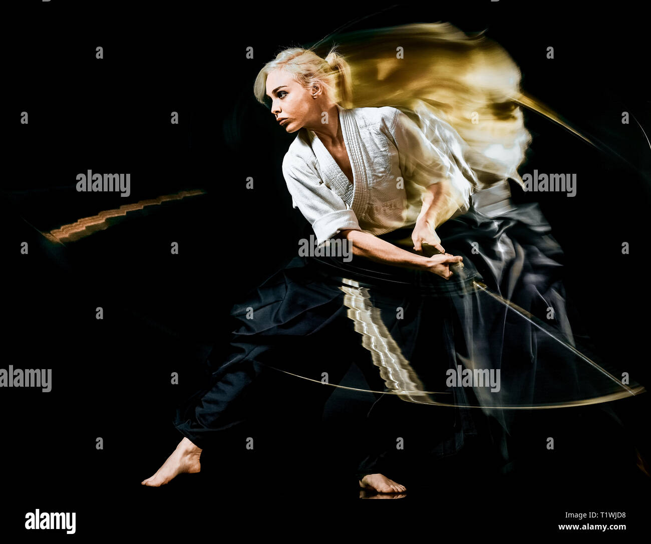 one budokas fighters woman practicing Iaido Kenjutsu studio shot ...