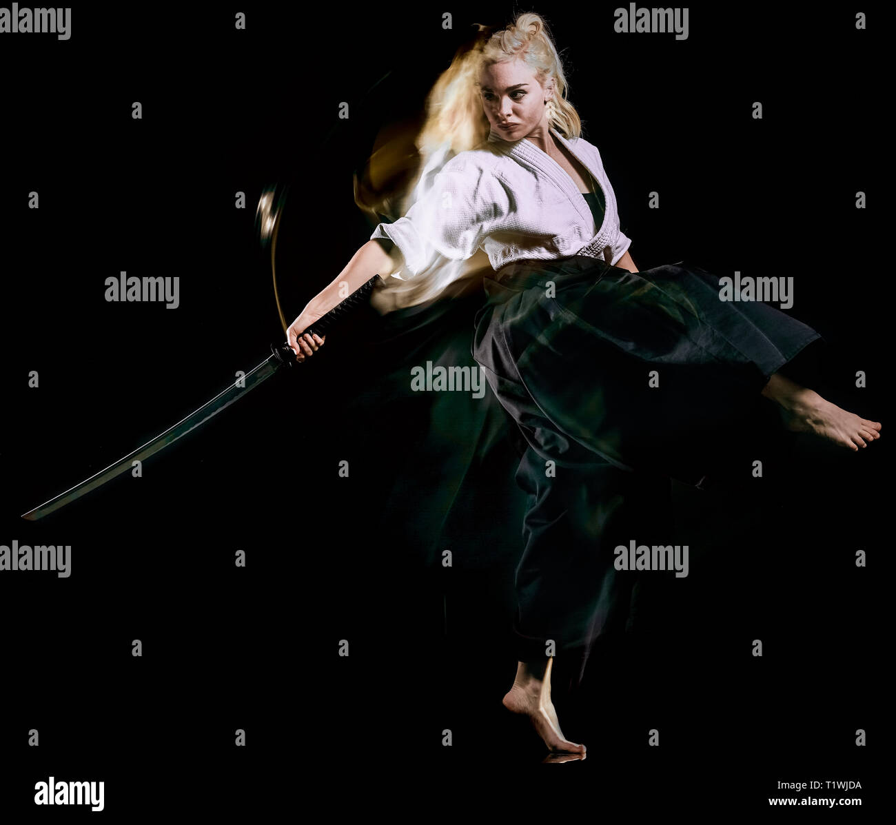 one budokas fighters woman practicing Iaido Kenjutsu studio shot ...