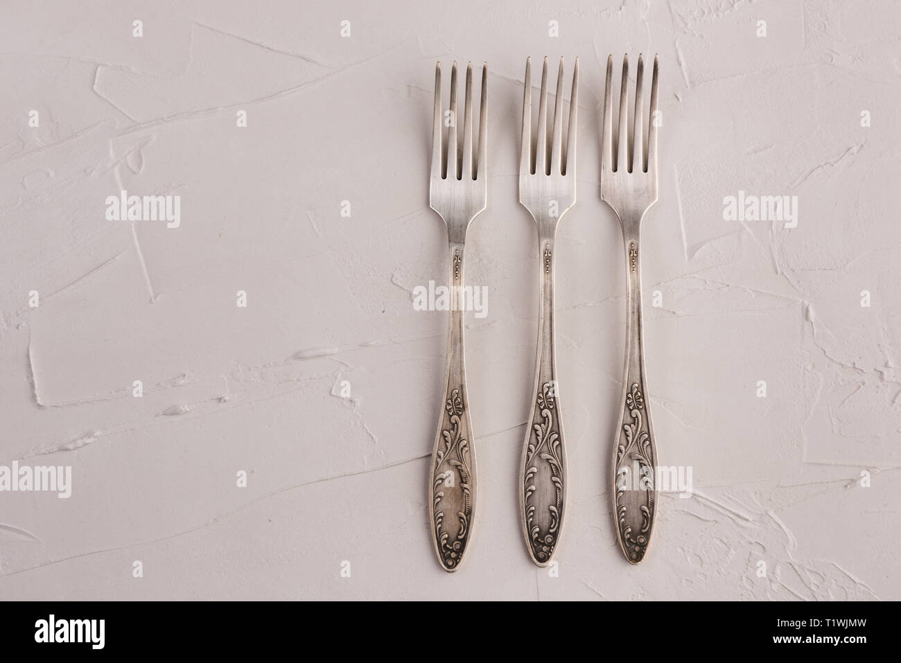 Very old rusty vintage set of three silver forks isolated on a white ...