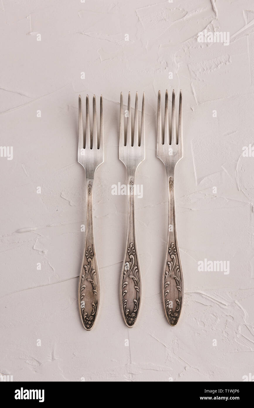 Very old rusty vintage set of three silver forks isolated on a white ...