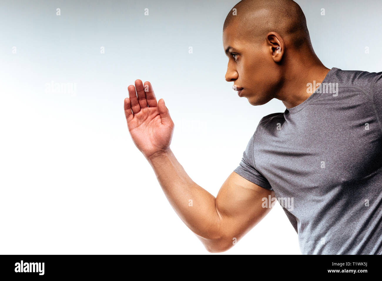 Concentrated man demonstrating his power while doing sports Stock Photo ...