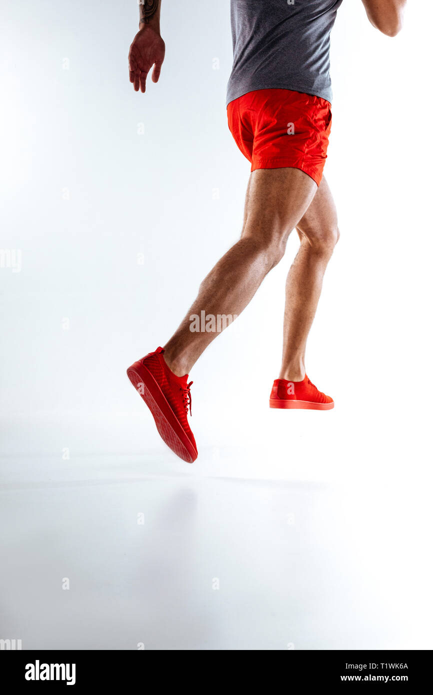 Sportive man in red shorts and snickers doing running movements Stock ...