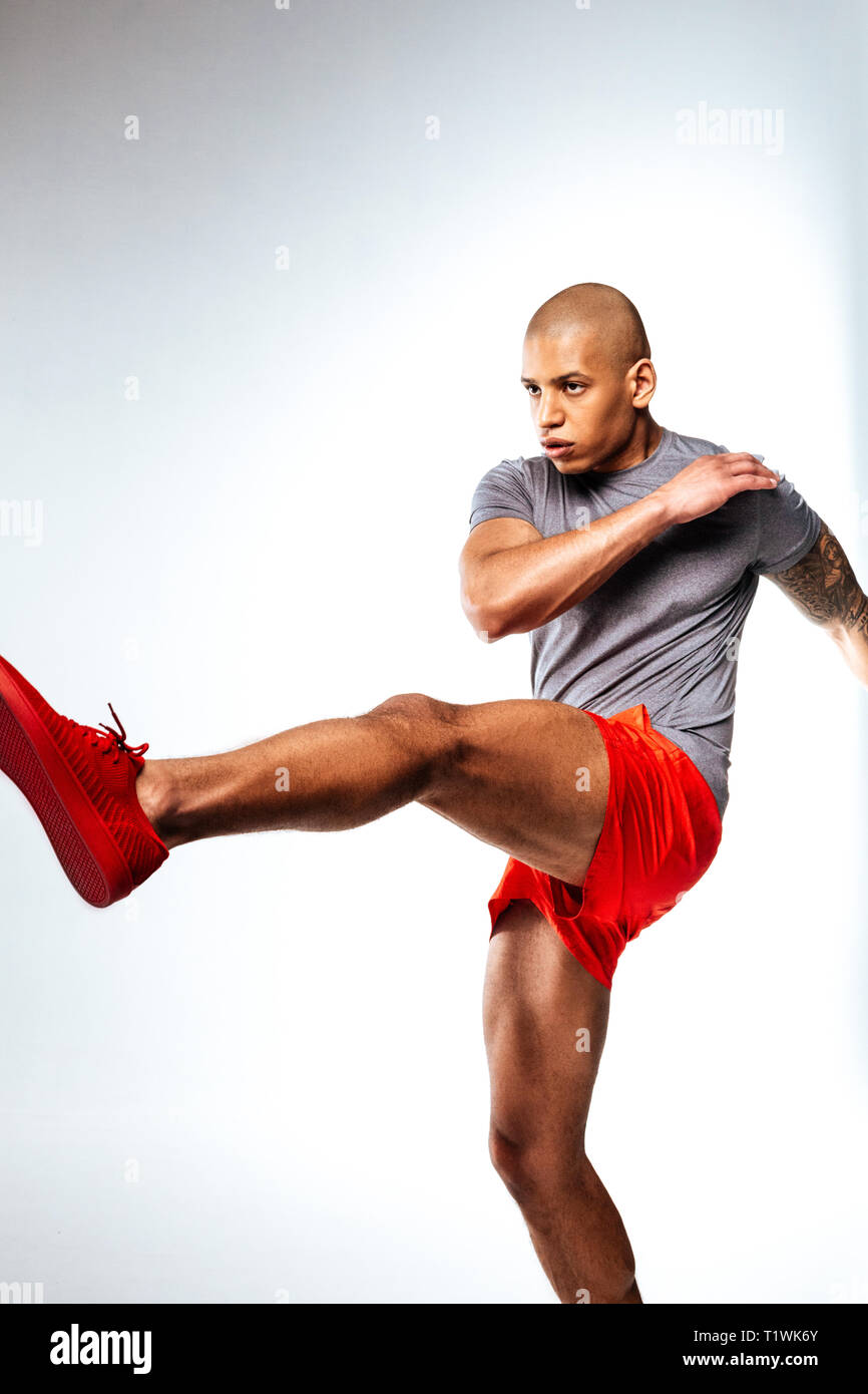 Sportive man moving his leg upwards like a football player Stock Photo ...