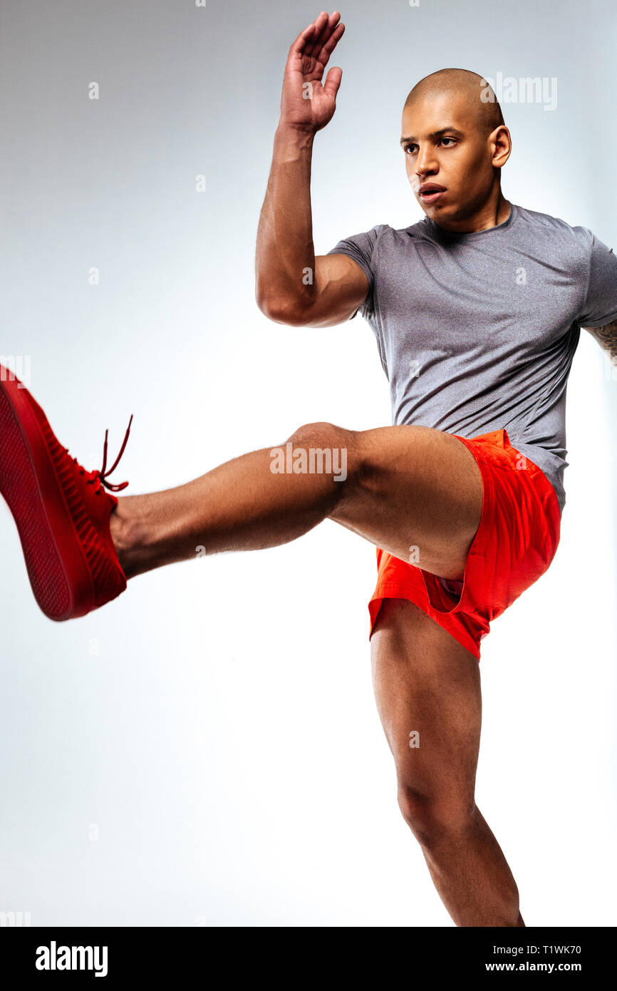Man moving his arm and leg upwards Stock Photo - Alamy