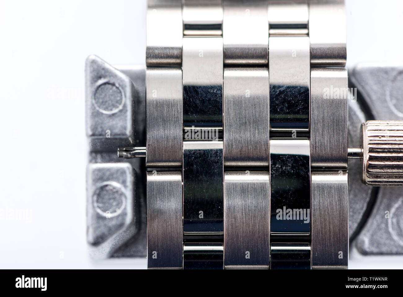A watch pin being pushed out of a watch band with a watch link remover ...