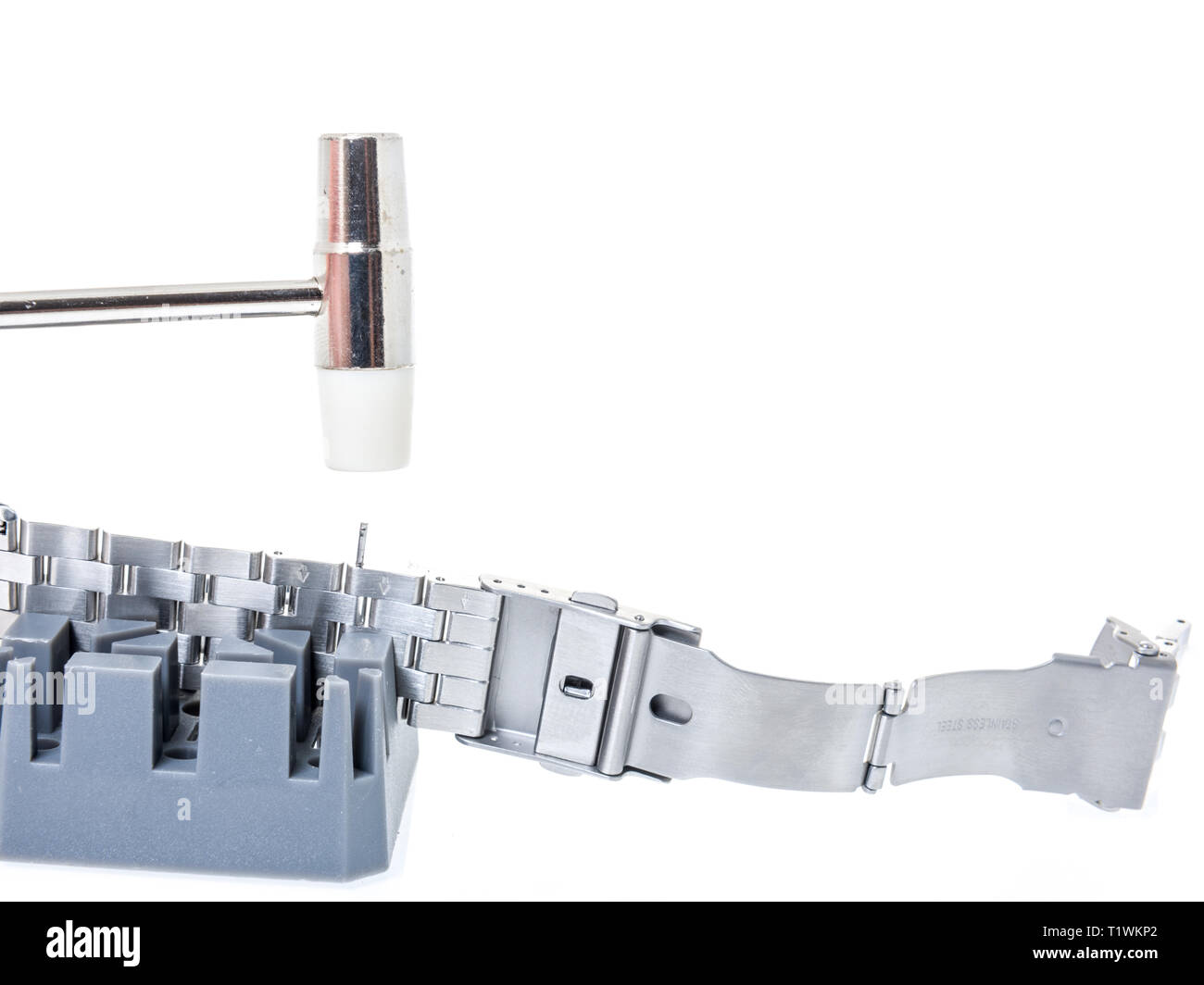 A watch pin being installed into watch band with hammer and a watch ...