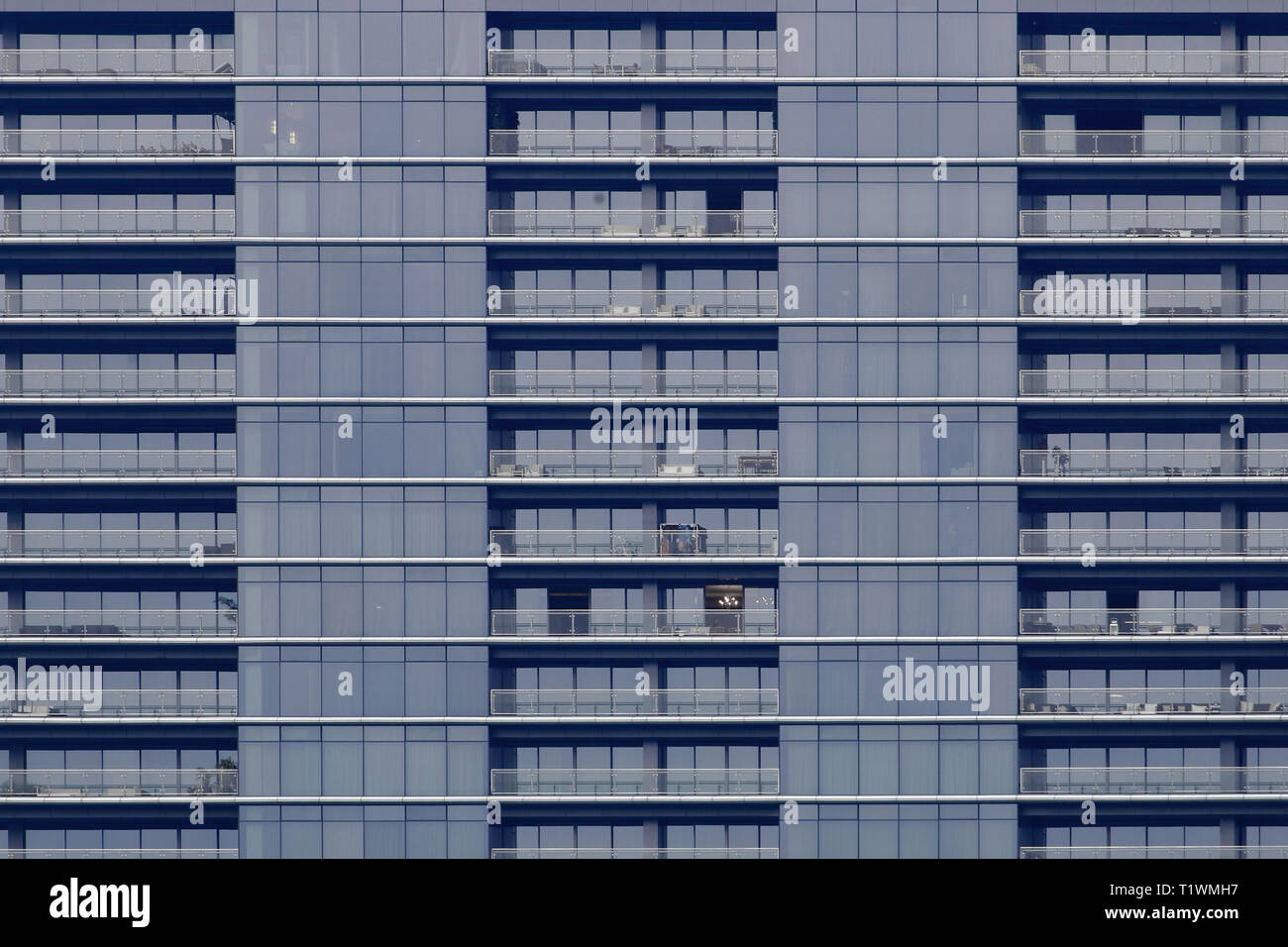 Building facade. modern hi-rise condominium clad with blue glass and ...