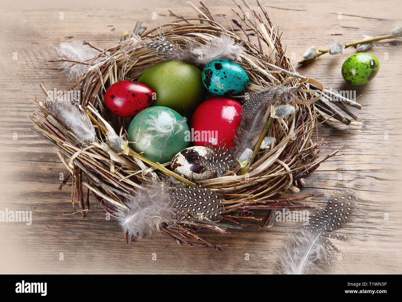 Easter eggs in nest on a wooden background. Happy Easter. Top view with ...