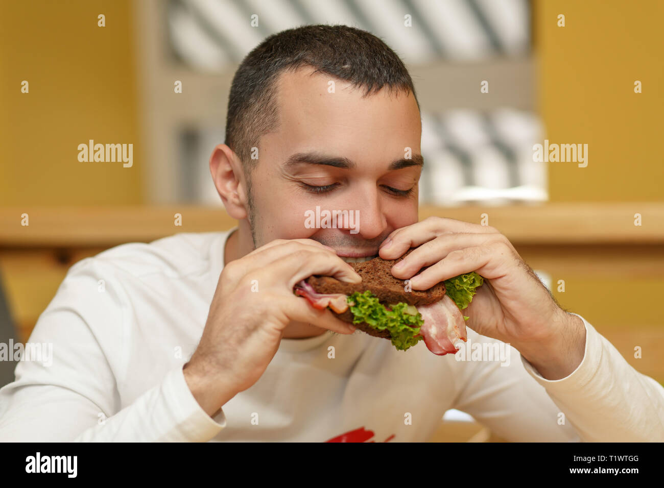 Happy guy holding sandwich looking hi-res stock photography and images ...