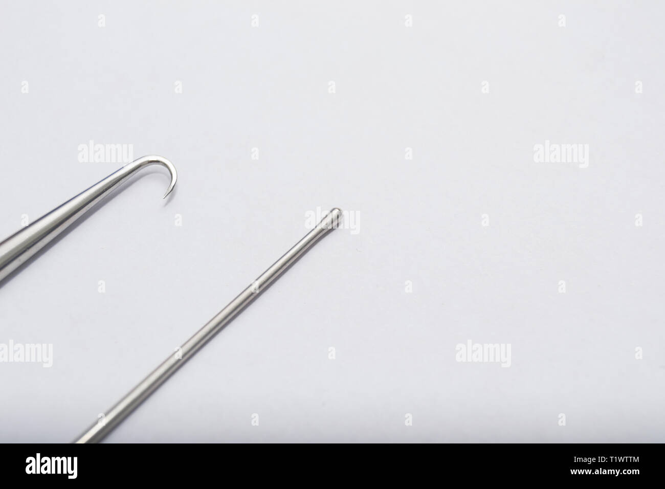 Buttoned probe and hook on grey surface Stock Photo - Alamy