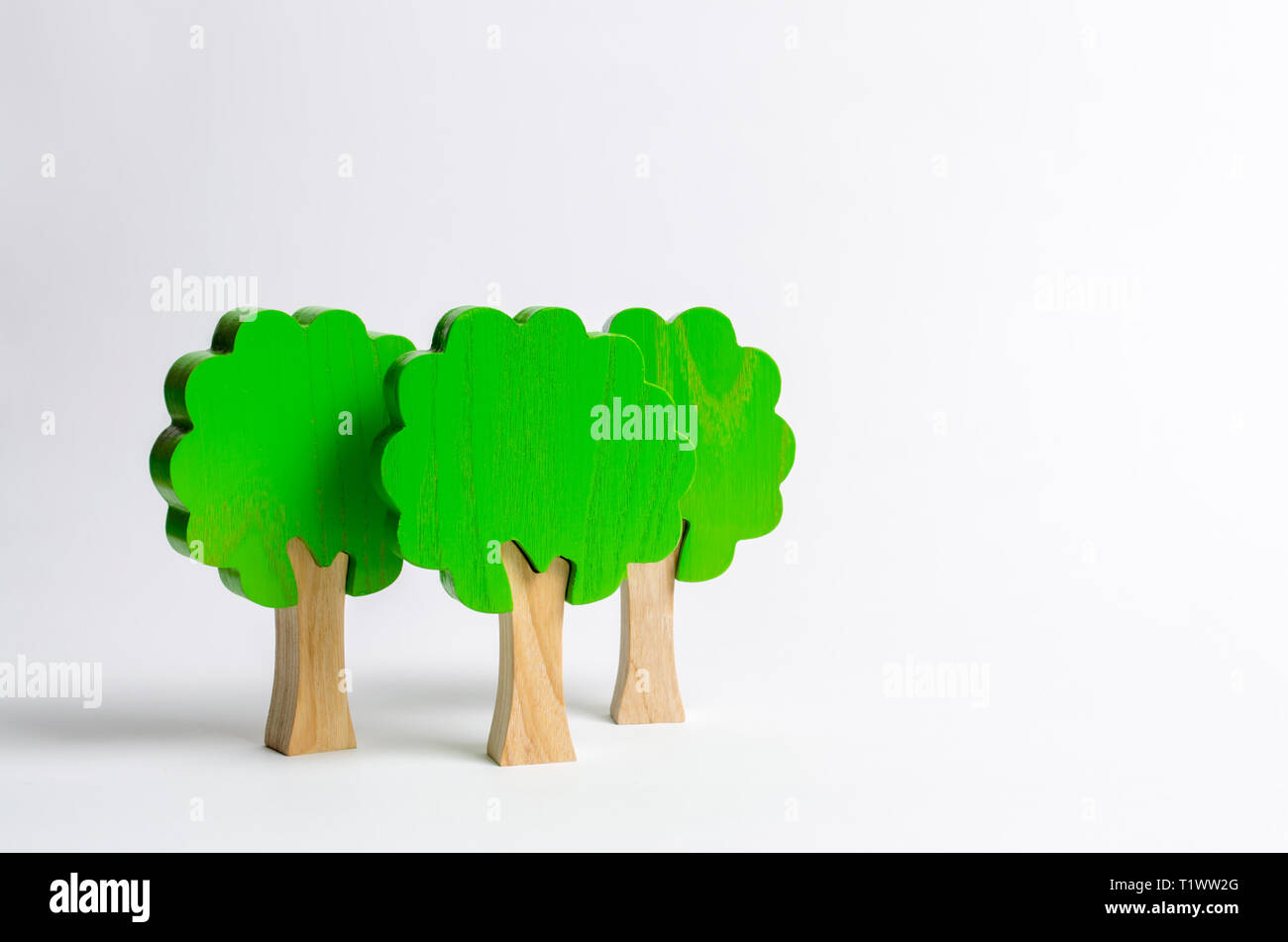 Three toy wooden figures of trees on a white background. Forest ...