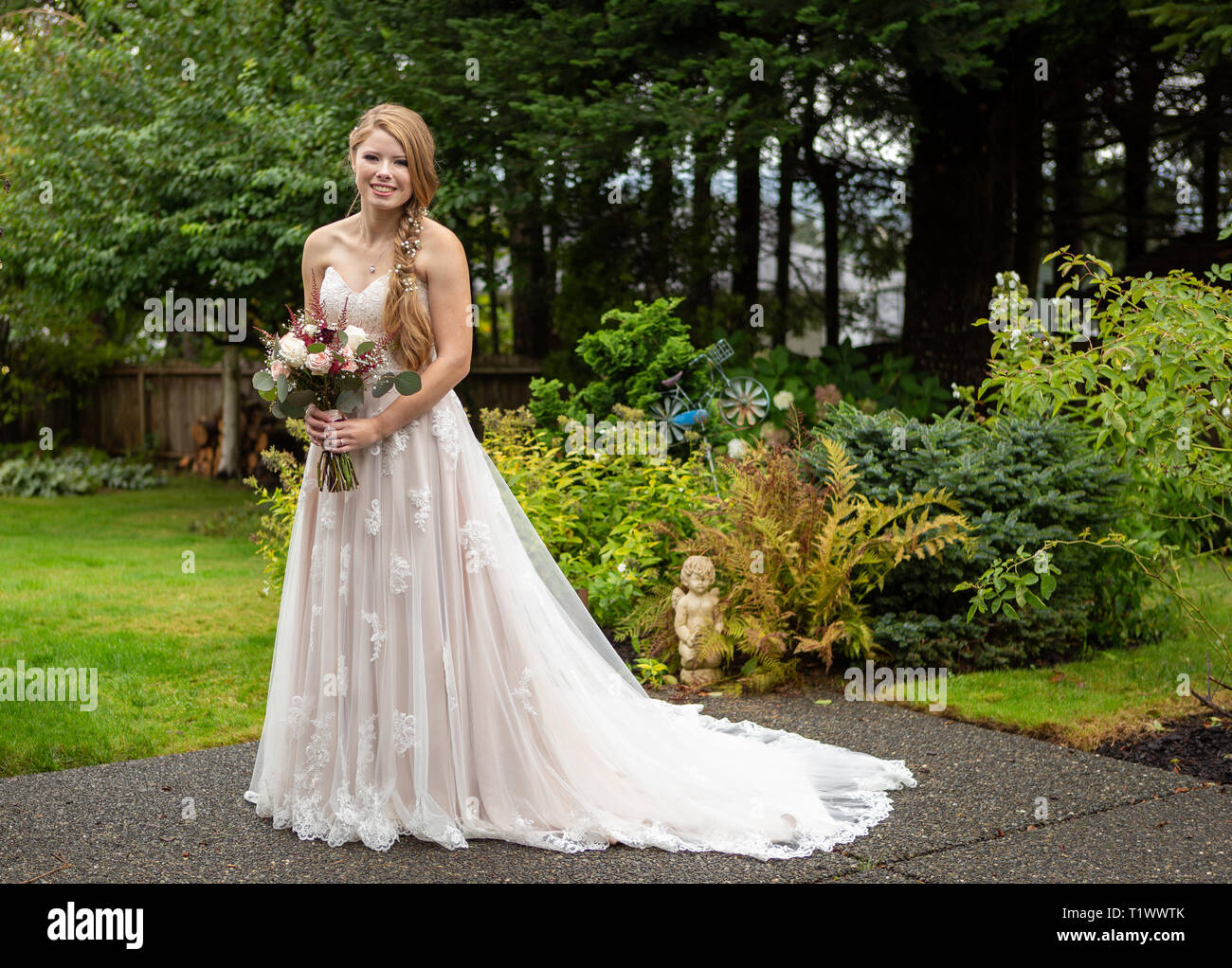 Young woman in wedding dress outside Stock Photo - Alamy