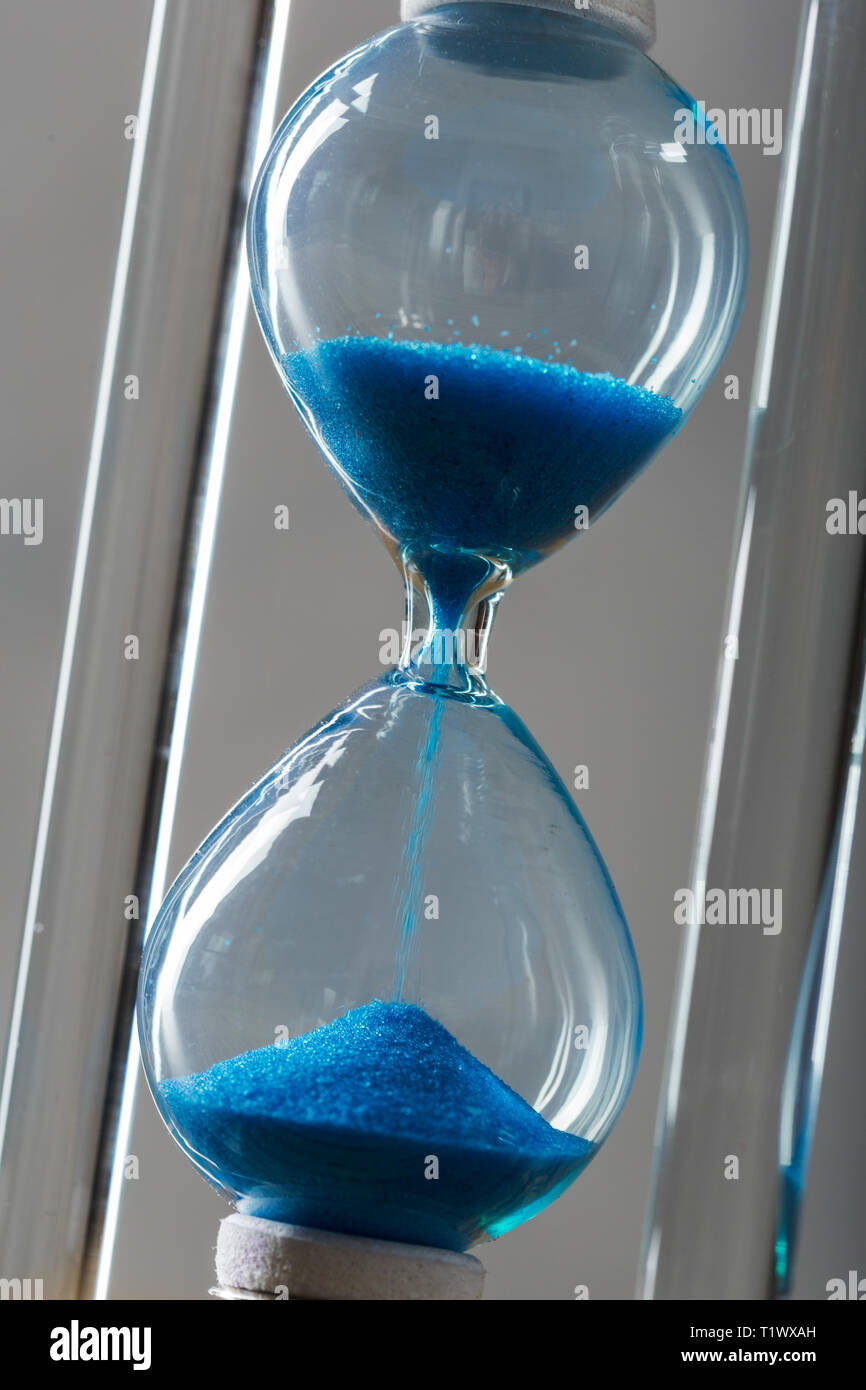 Time is passing. Blue hourglass close up Stock Photo - Alamy