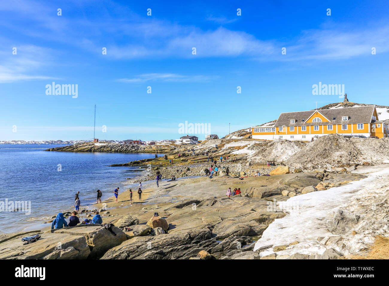 Beach time for Inuit people enjoying the sunny May day at the sea fjord ...