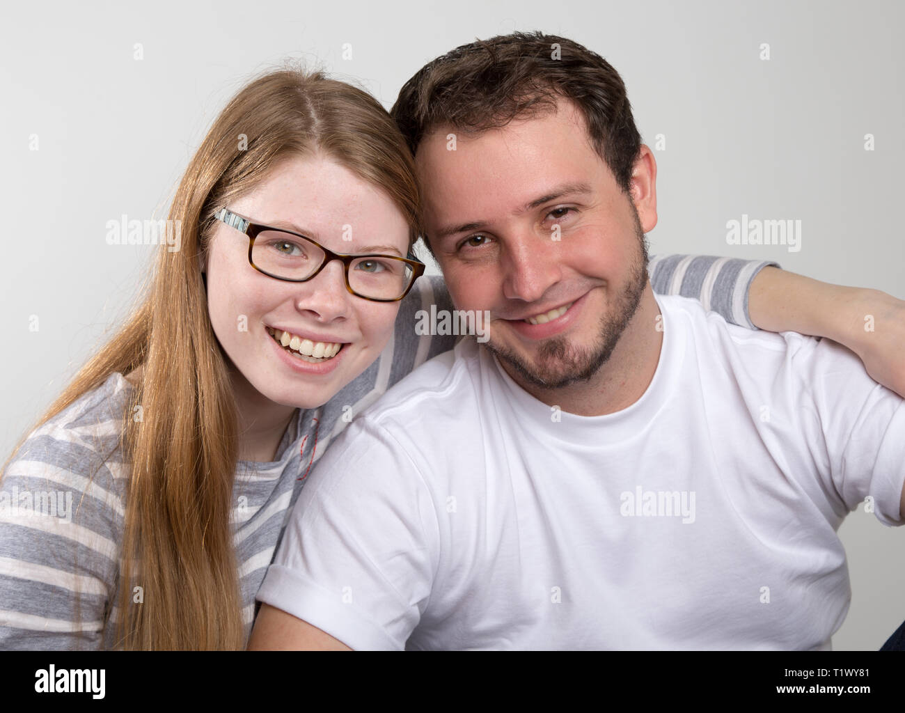 Young couple smiling together in studio Stock Photo - Alamy