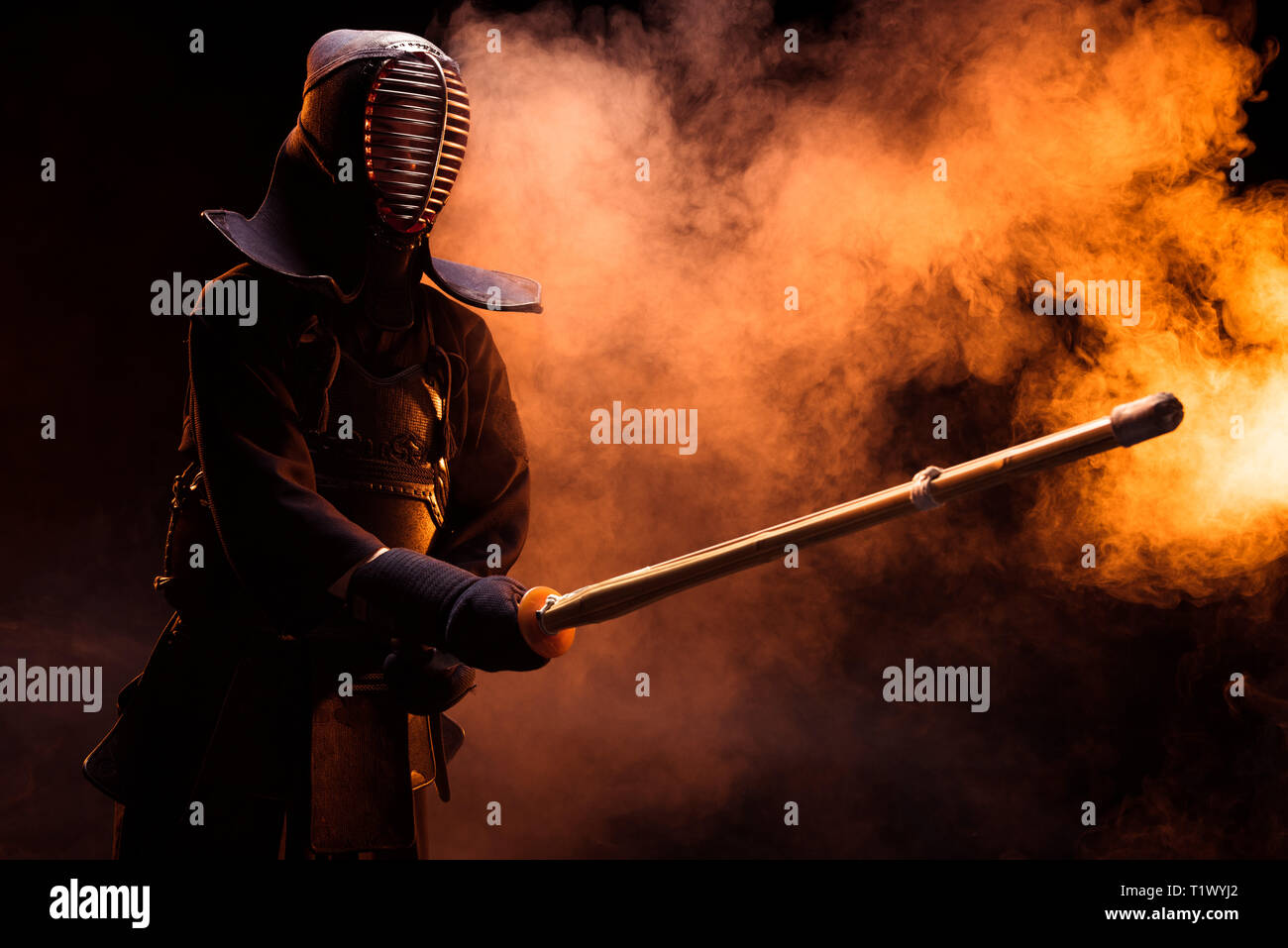 Kendo fighter in armor practicing with bamboo sword in smoke Stock ...