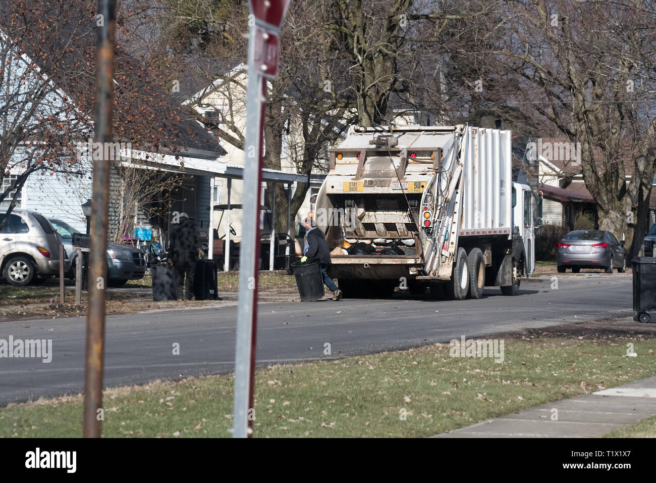 Men loading a white back load garbage truck Stock Photo - Alamy