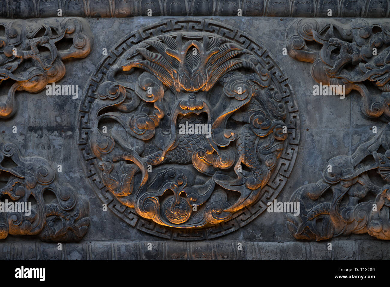 Carving of a Chinese dragon in an octagon on a temple wall in Xi'An ...