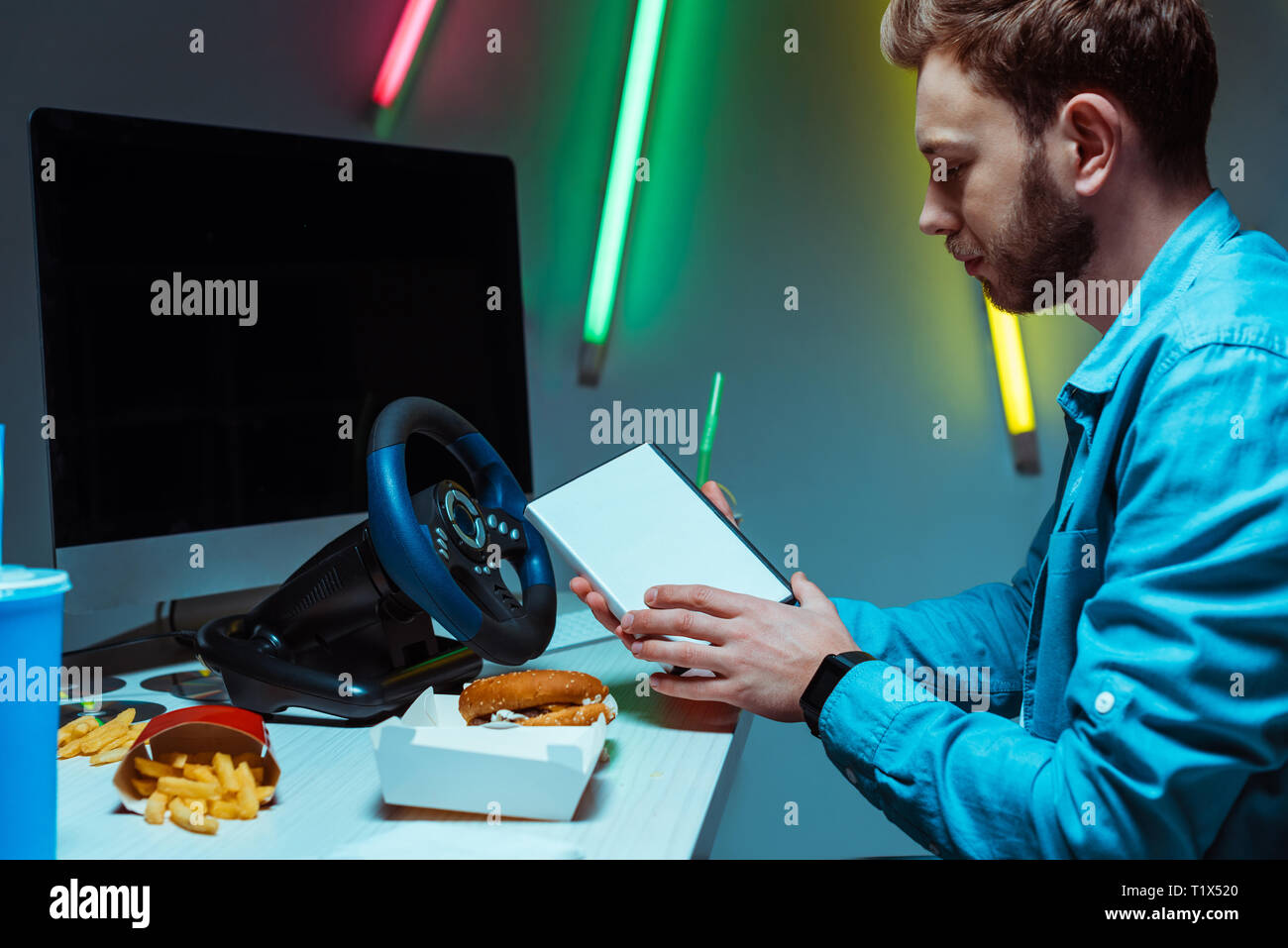 side view of handsome and good-looking man holding compact disk with ...