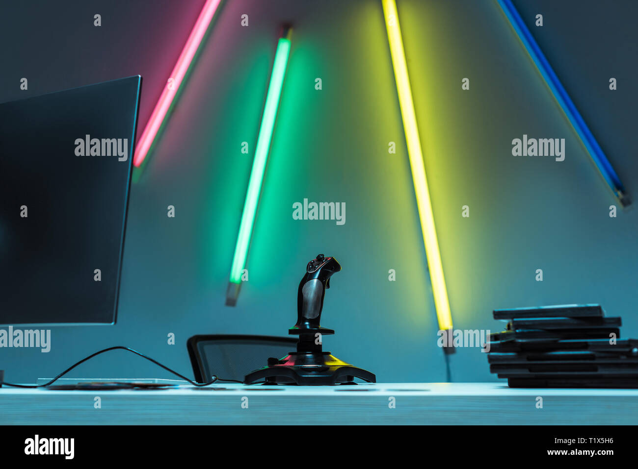 computer monitor, joystick and compact disks with video games on table ...