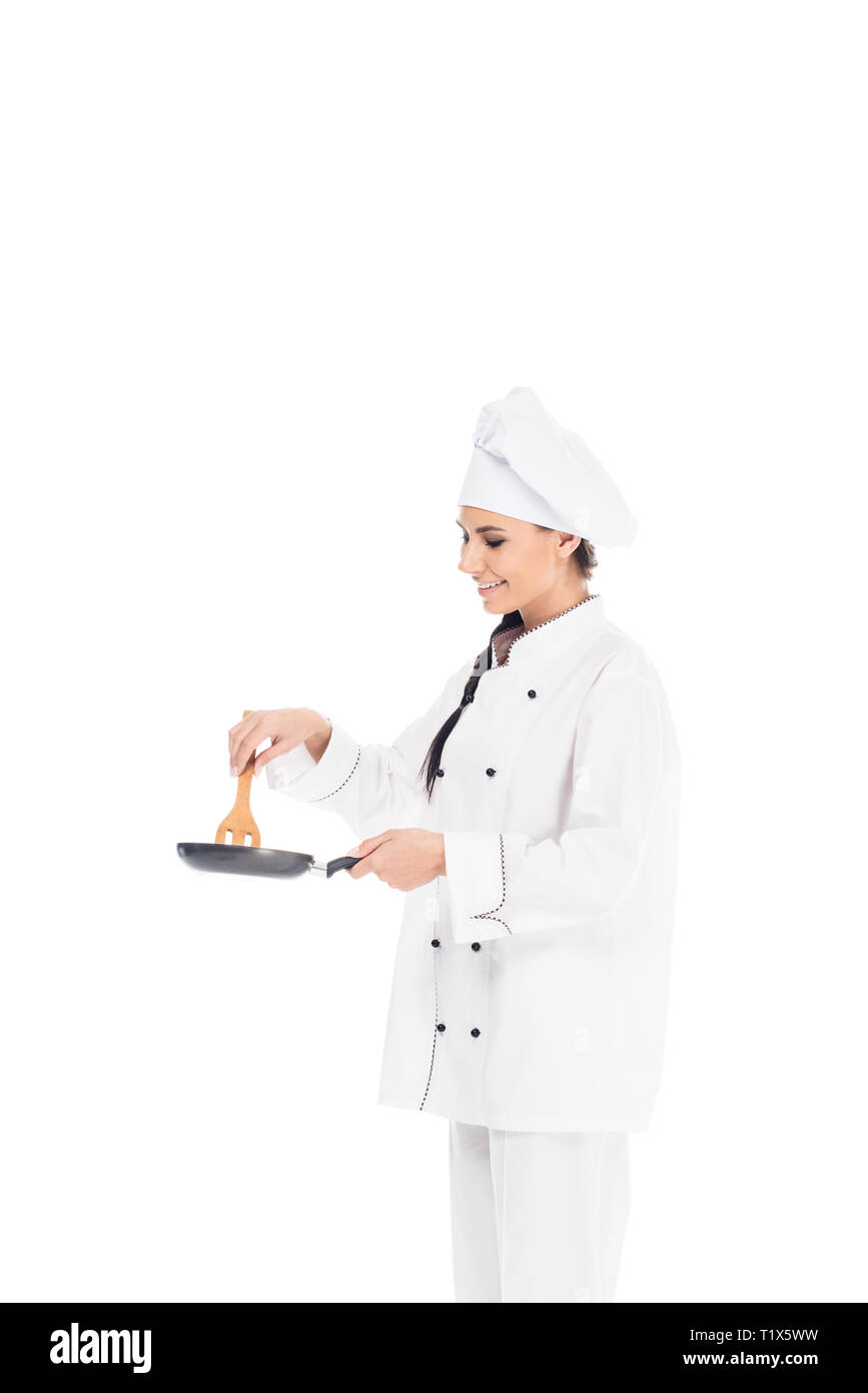 Chef in hat holding frying pan and wooden kitchen spatula isolated on ...