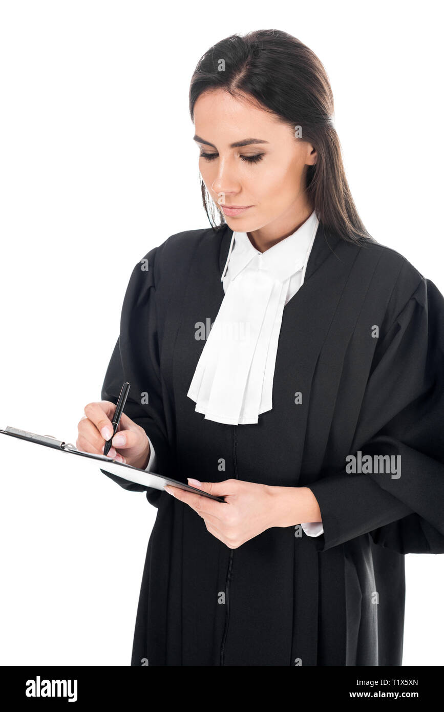 Concentrated judge in judicial robe writing in clipboard isolated on ...