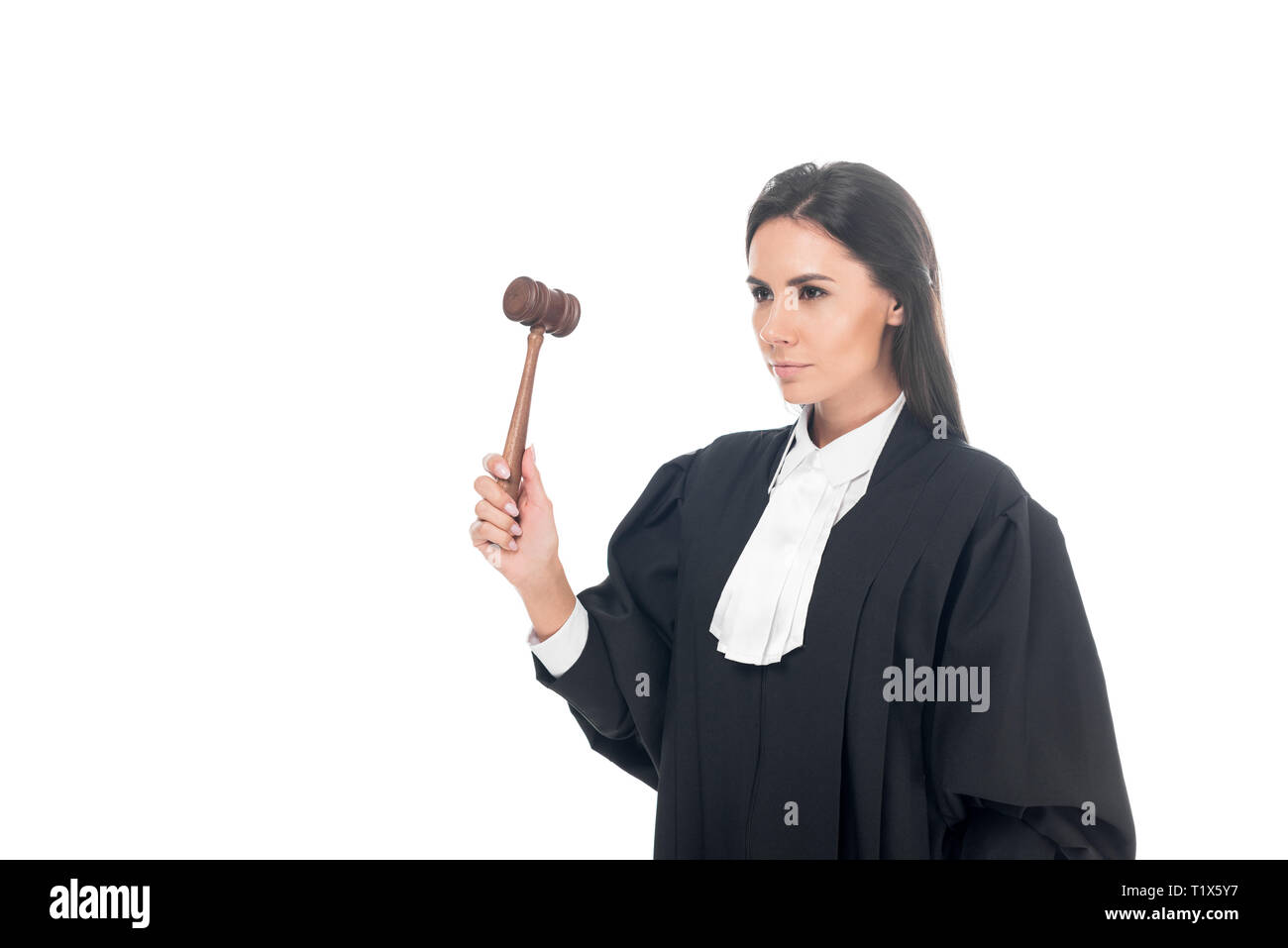 Serious brunette judge in judicial robe holding gavel isolated on white ...