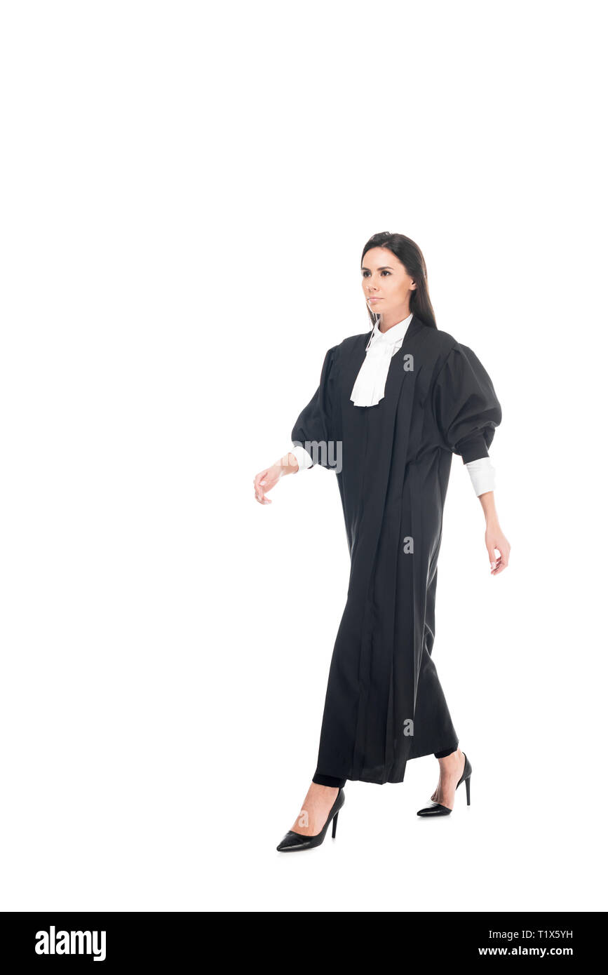 Full length view of serious judge in judicial robe walking isolated on ...