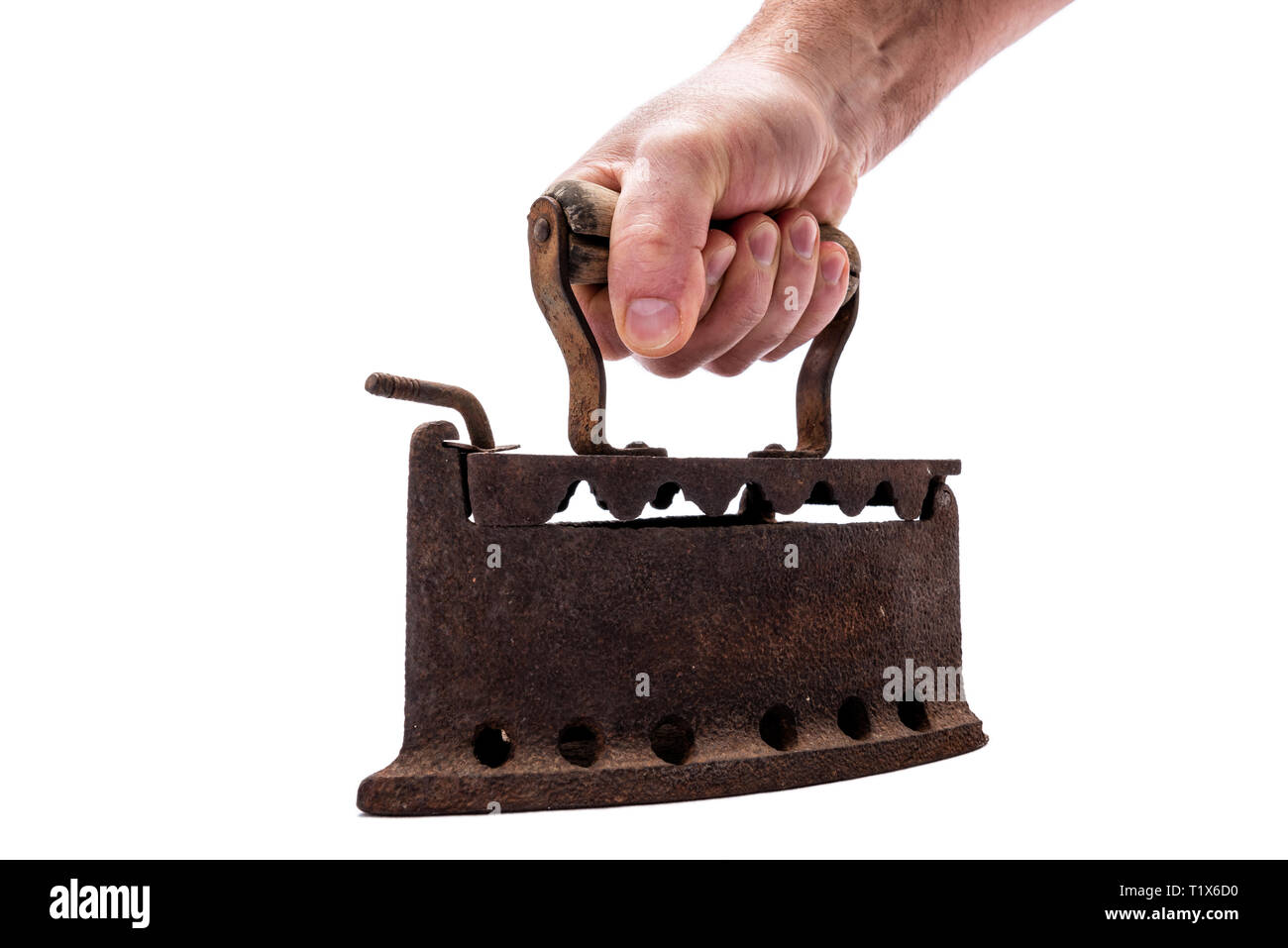 Hand strongly holding an antique and rusty iron from coal ironing with ...