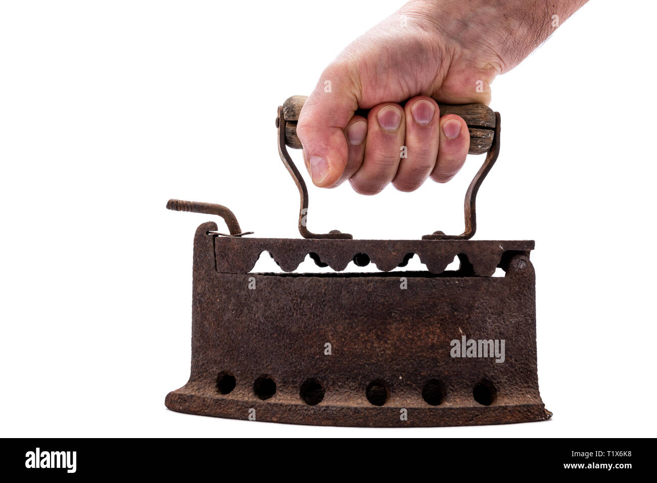 Hand strongly holding an antique and rusty iron from coal ironing with ...