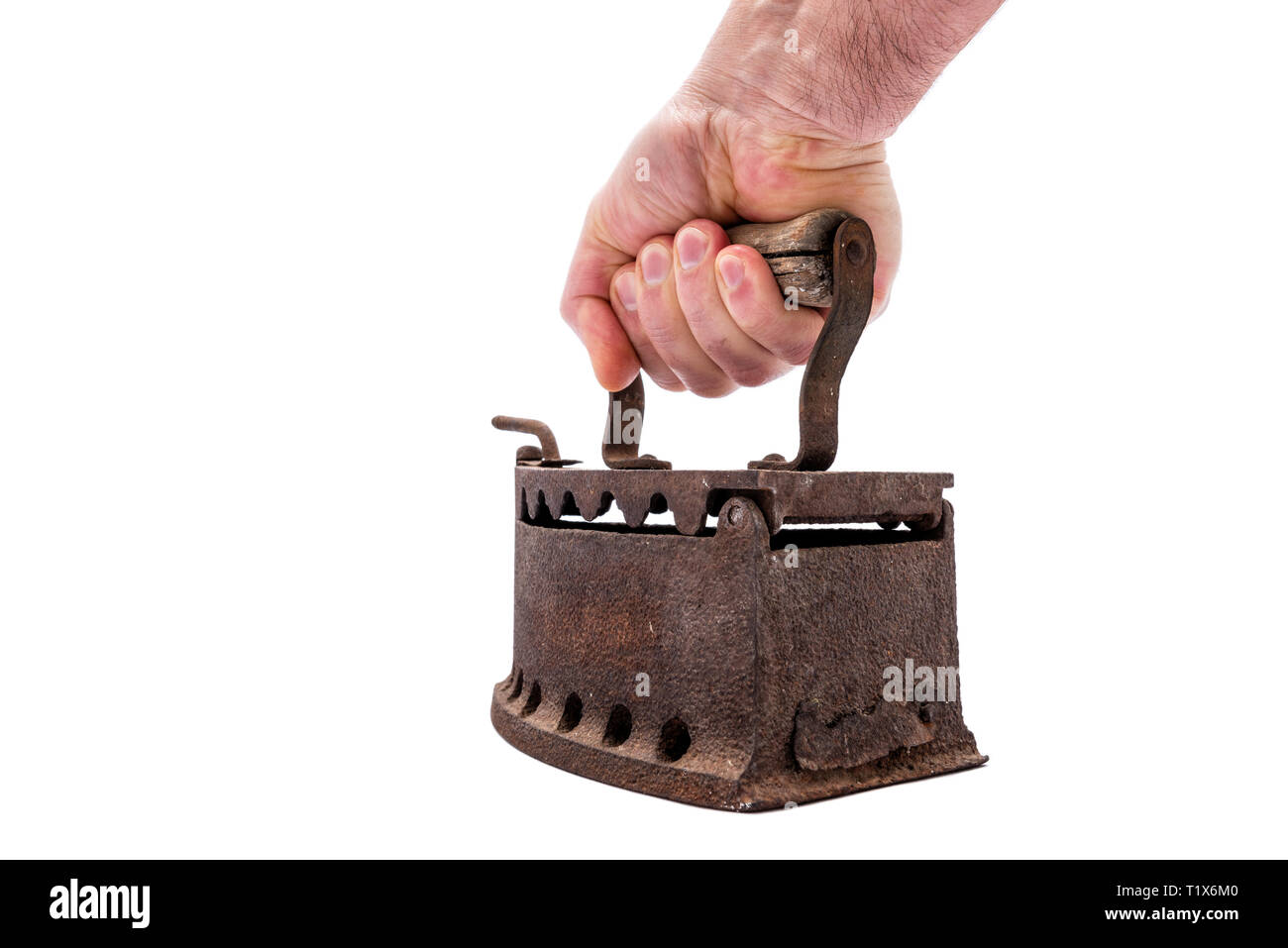 Hand strongly holding an antique and rusty iron from coal ironing with ...