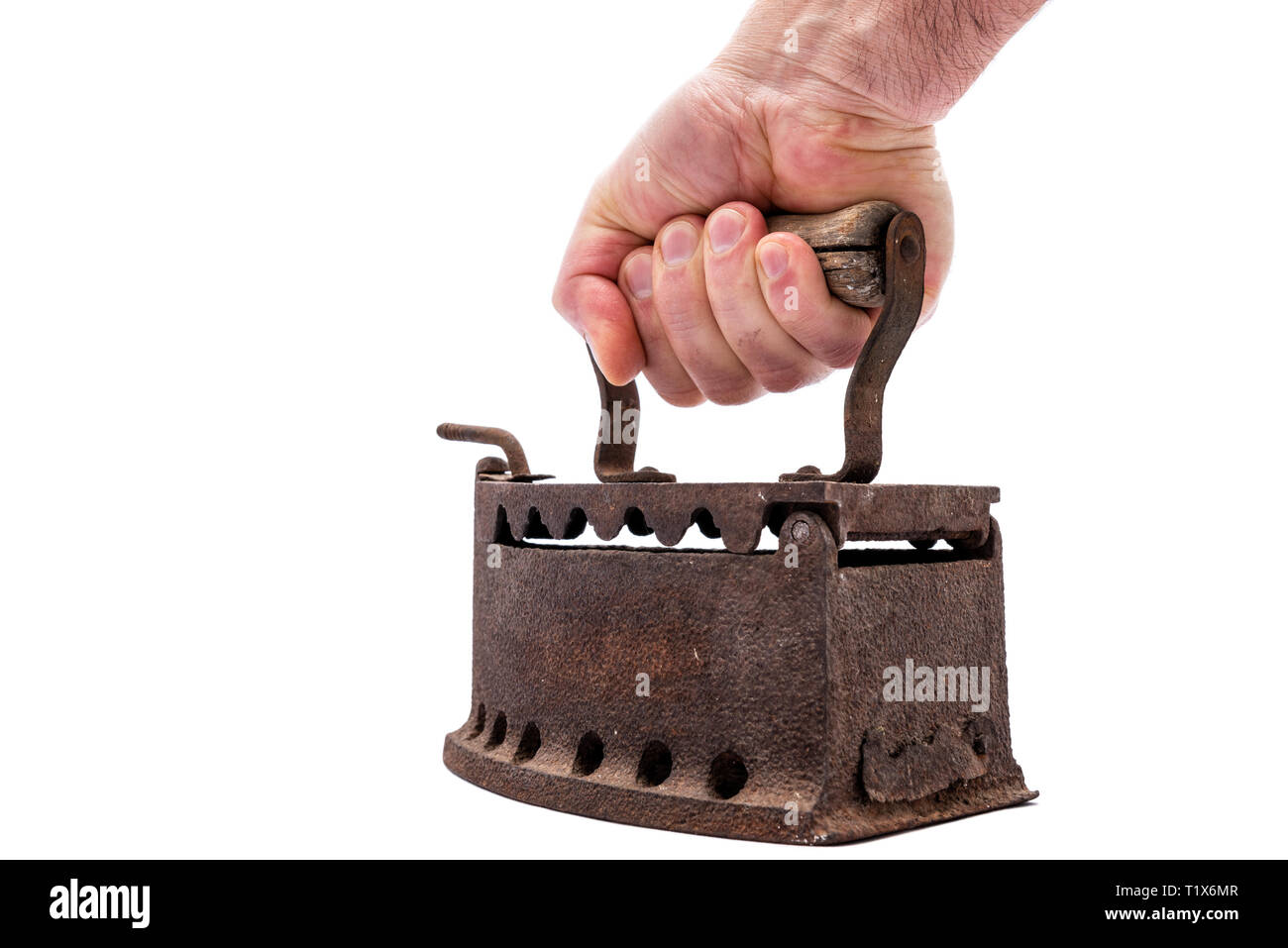 Hand strongly holding an antique and rusty iron from coal ironing with ...