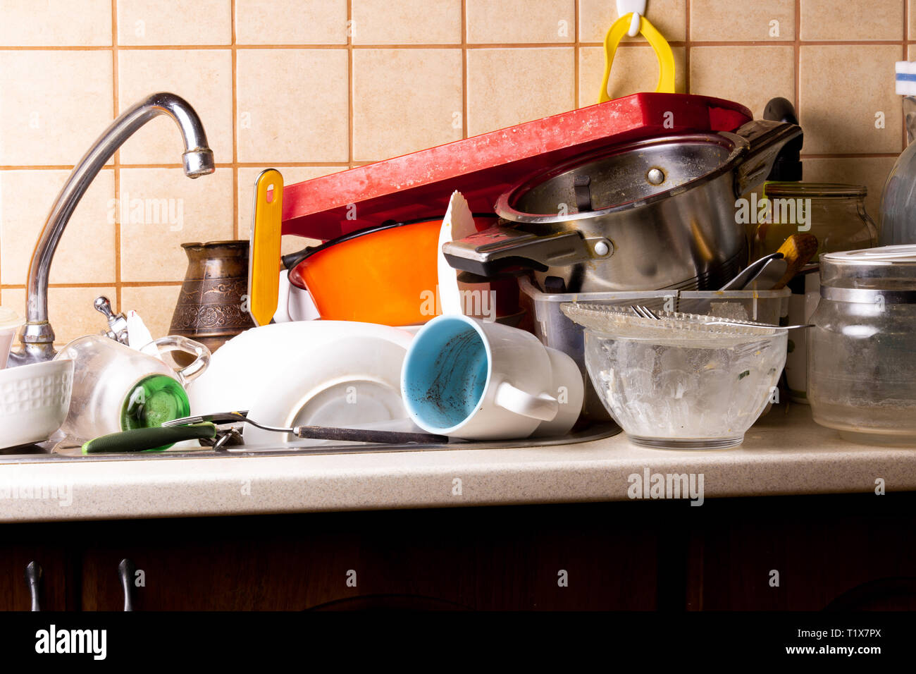 A lot of dirty dishes lie in the sink in the kitchen that needs to be ...