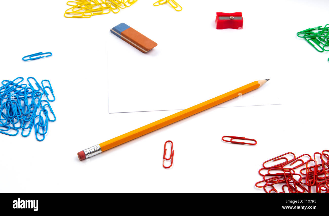 Pencil, eraser, sharpener, paper clips lie in different angles of the ...