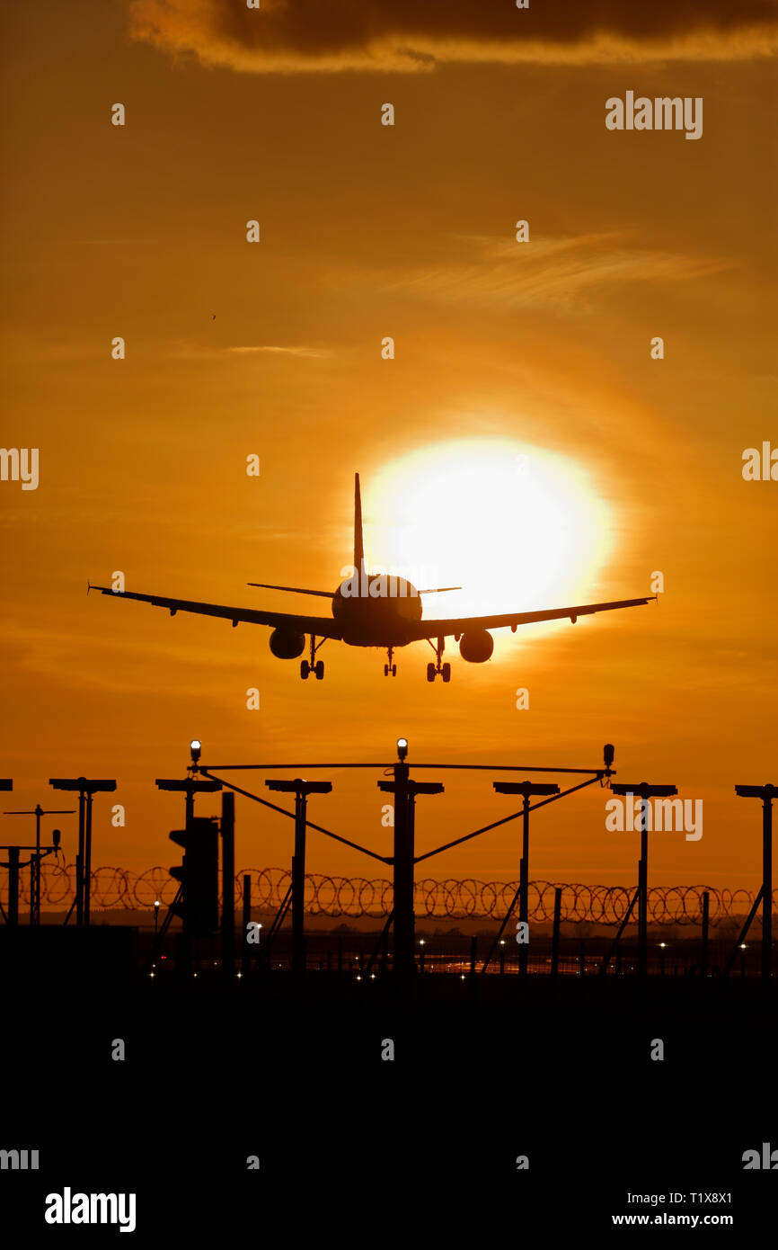 Airliner landing at Heathrow airport at sunset Stock Photo - Alamy