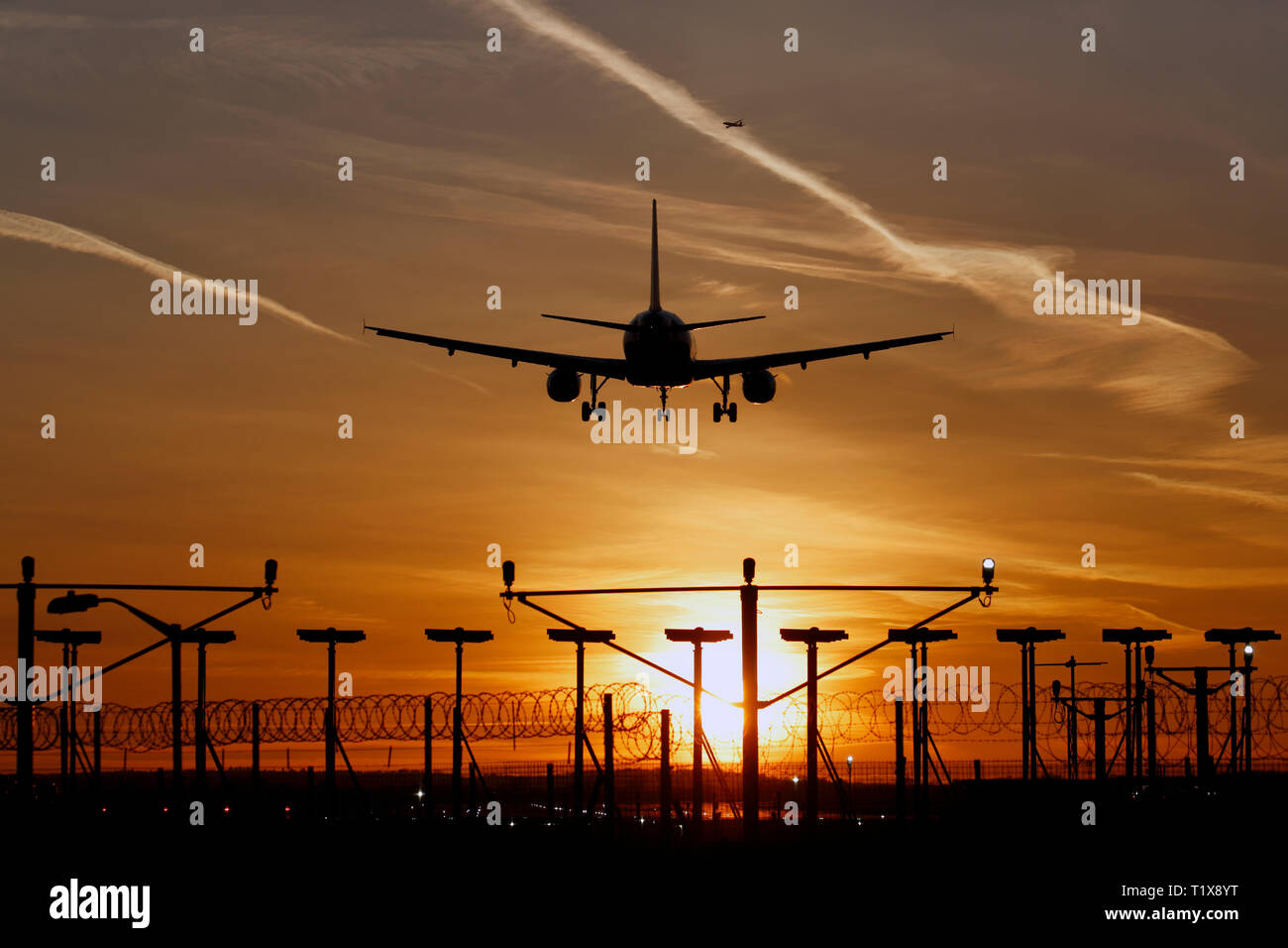 Airliner landing at Heathrow airport at sunset Stock Photo - Alamy