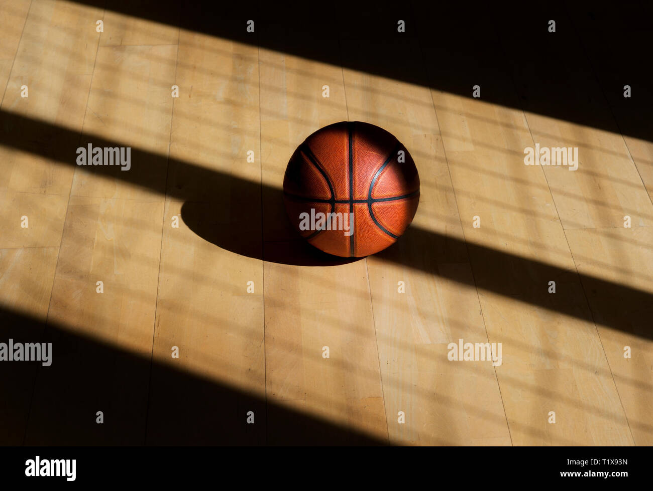 Basketball ball on the parquet with black background Stock Photo - Alamy