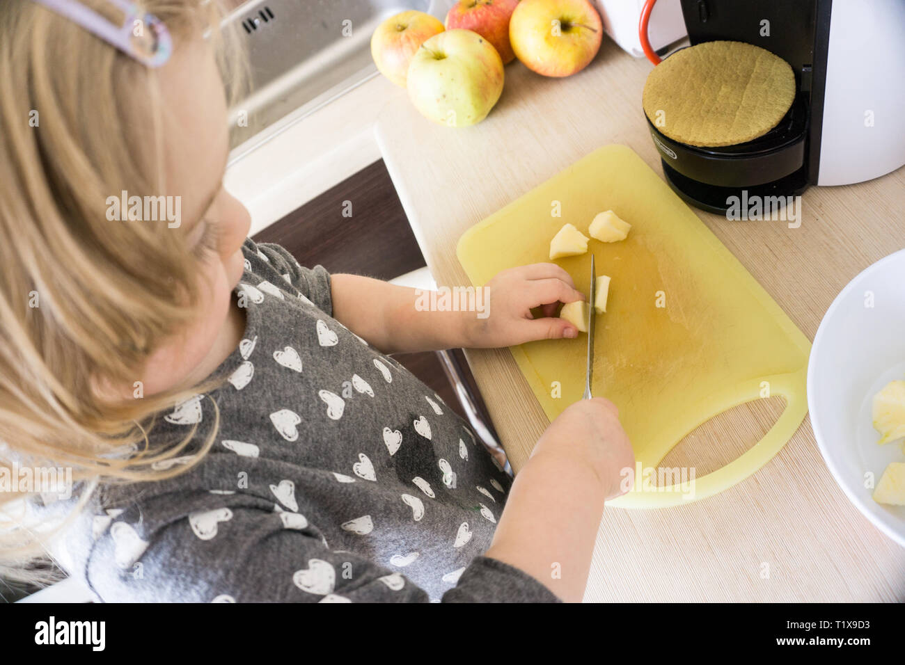 Child helps mother to cut apples for preparing fruit smoothie Stock ...