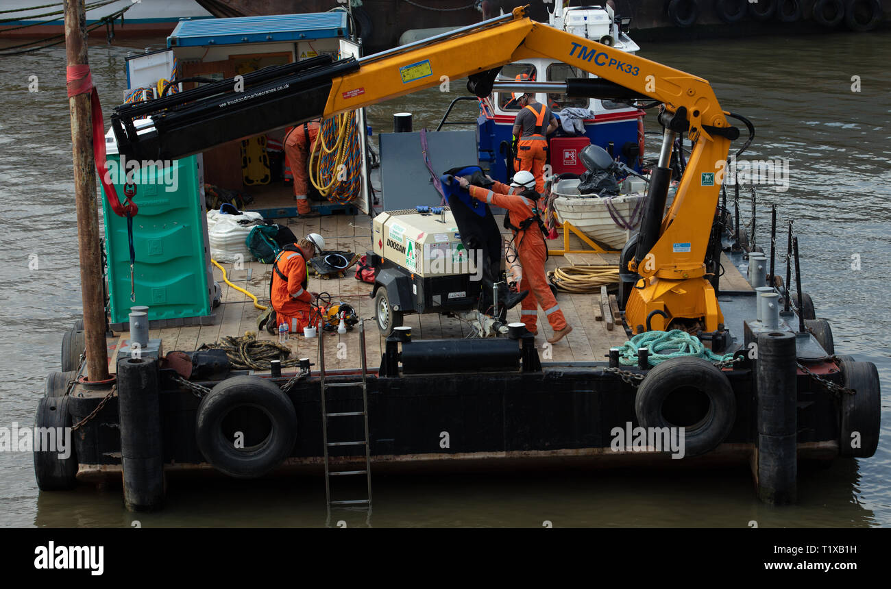 A crew of maintenance workers on a floating platform clear up after a ...