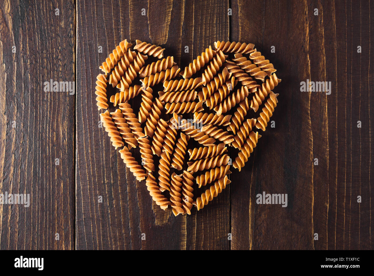 Heart shaped pasta on dark wooden background Stock Photo - Alamy