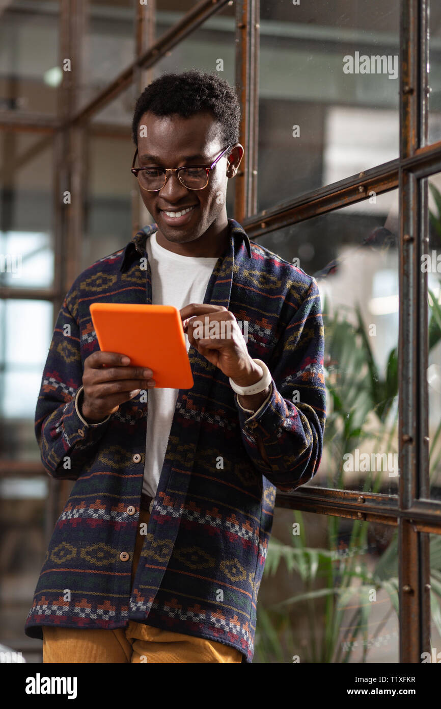Smiling man using a tablet in a bright case Stock Photo - Alamy
