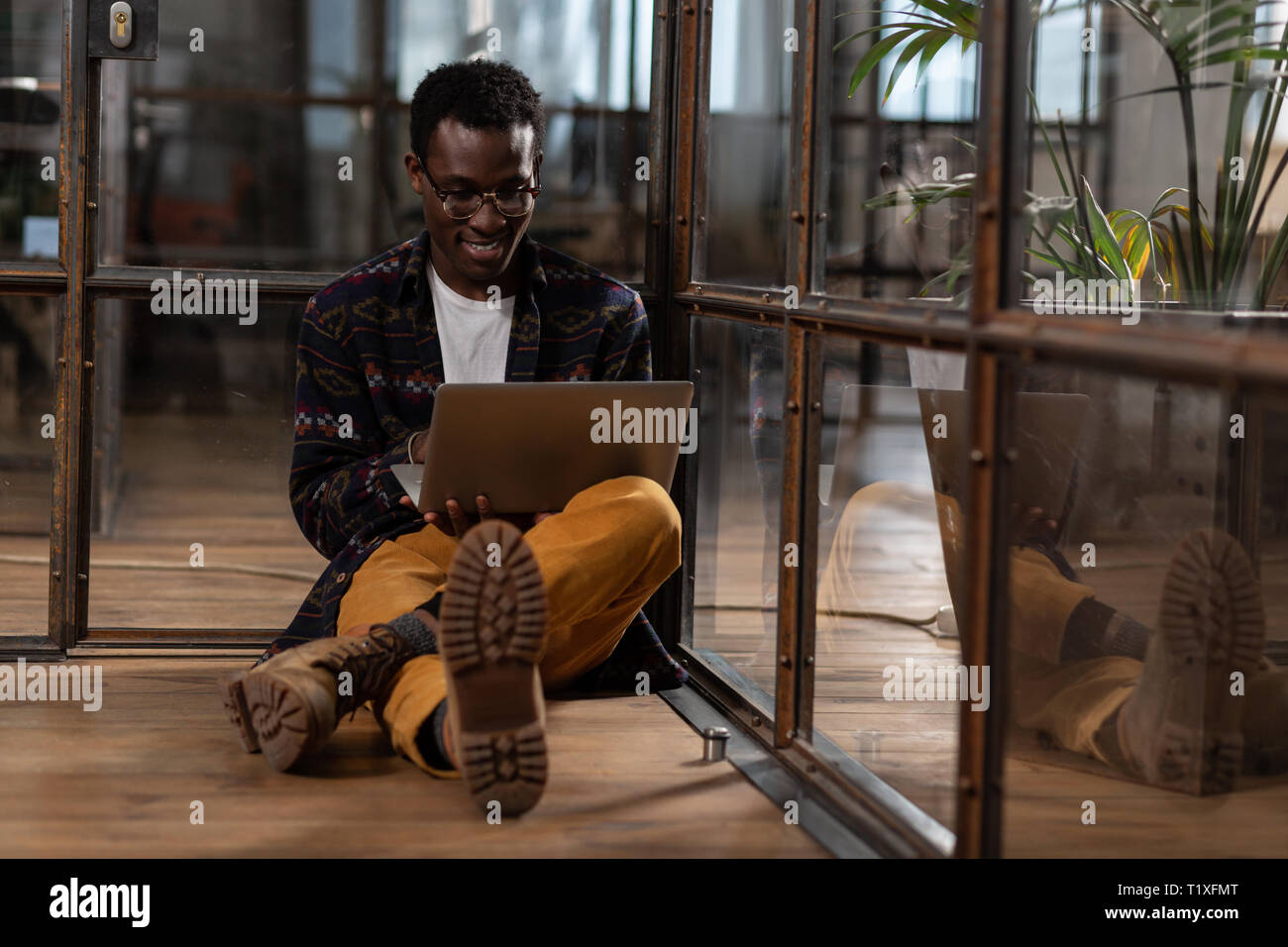 Man sitting on the floor while working with computer Stock Photo - Alamy