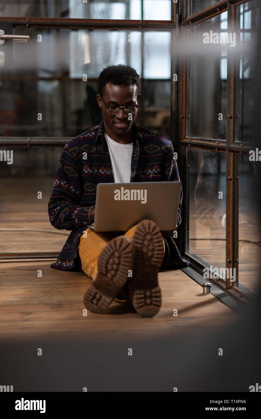 Man using computer while sitting without chair Stock Photo - Alamy