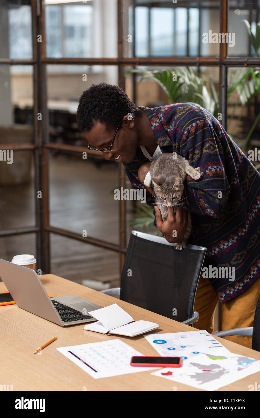 Man taking cat away from his computer Stock Photo - Alamy