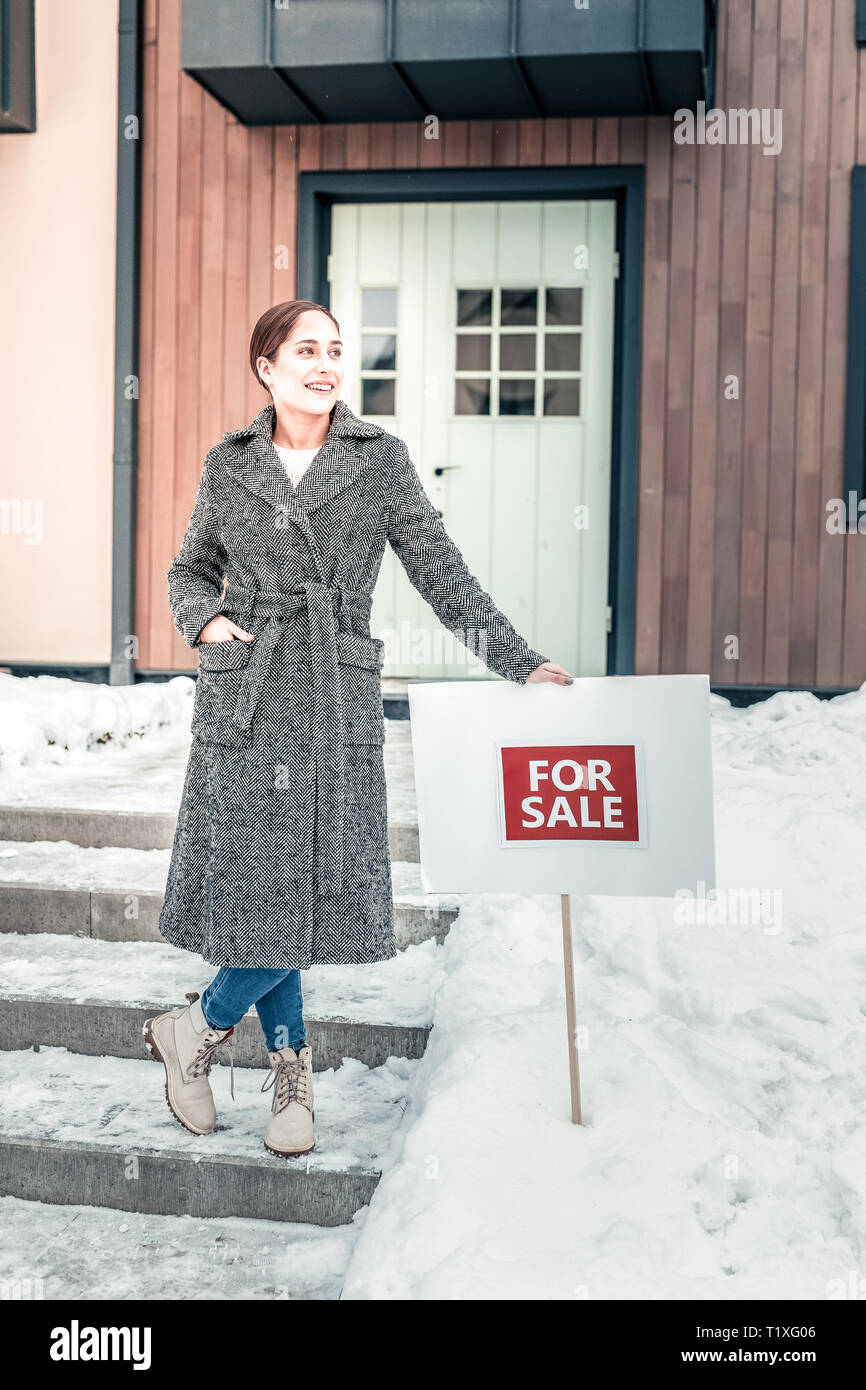 Beautiful stylish woman putting for sale sign near her house Stock ...