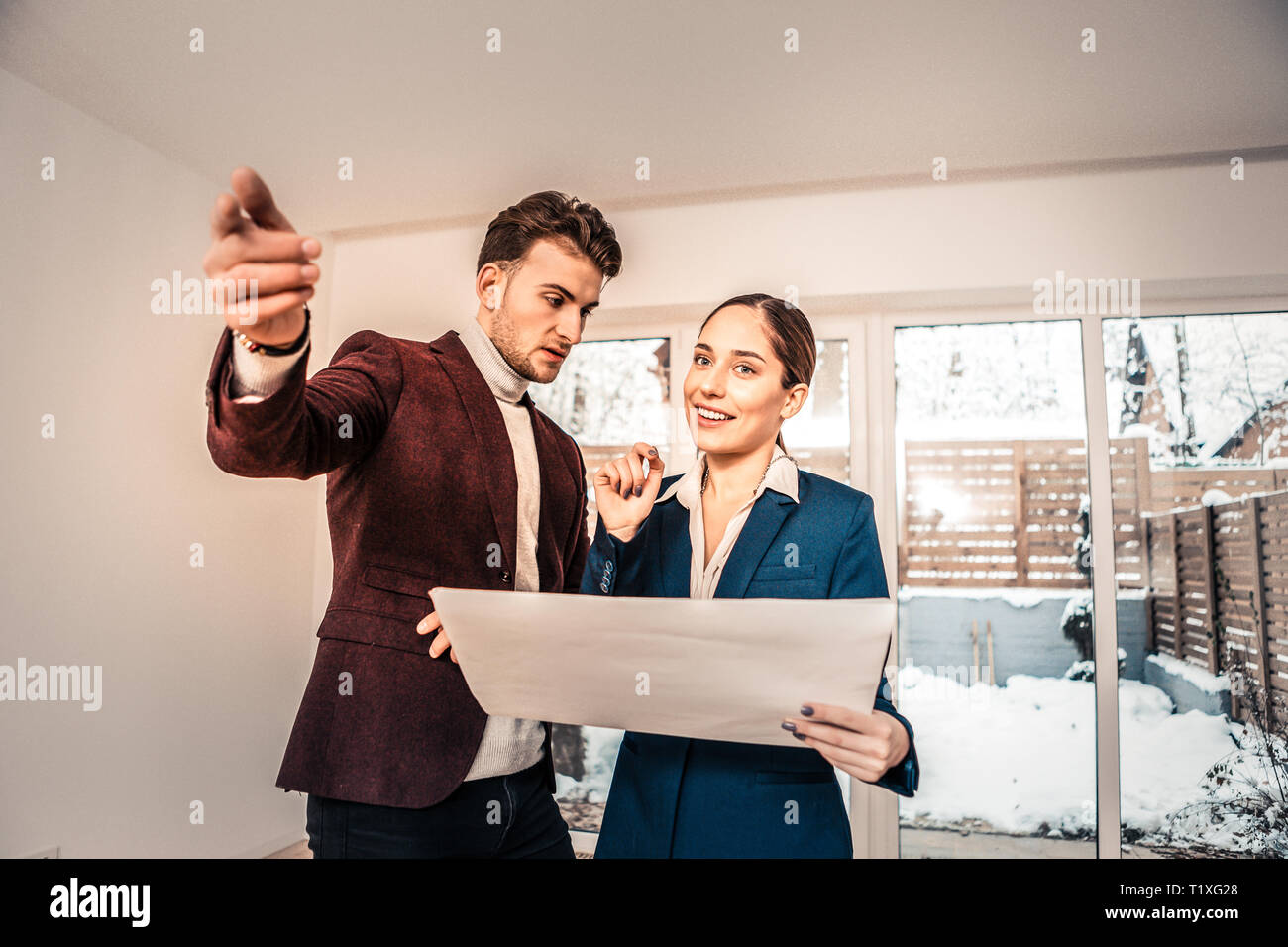 Beautiful realtor wearing blue jacket answering questions of client ...