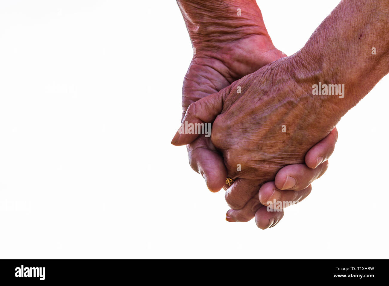 Cropped shot of elderly couple holding hands outdoor with white ...