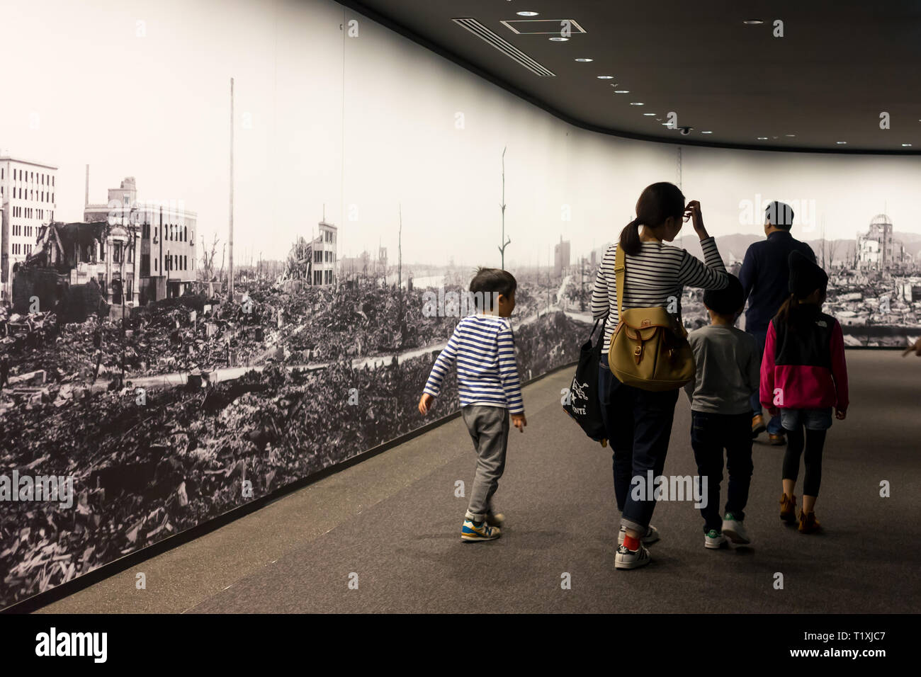 Visitors looking at a large photograph with the destruction of the city ...
