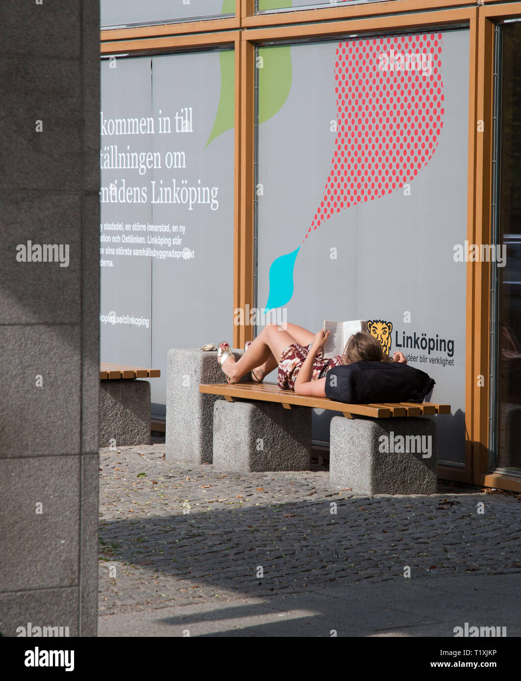 Someone reading a book outside a library Stock Photo - Alamy